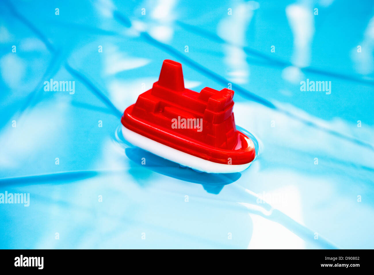 A red plastic boat floating in a swimming-pool Stock Photo - Alamy