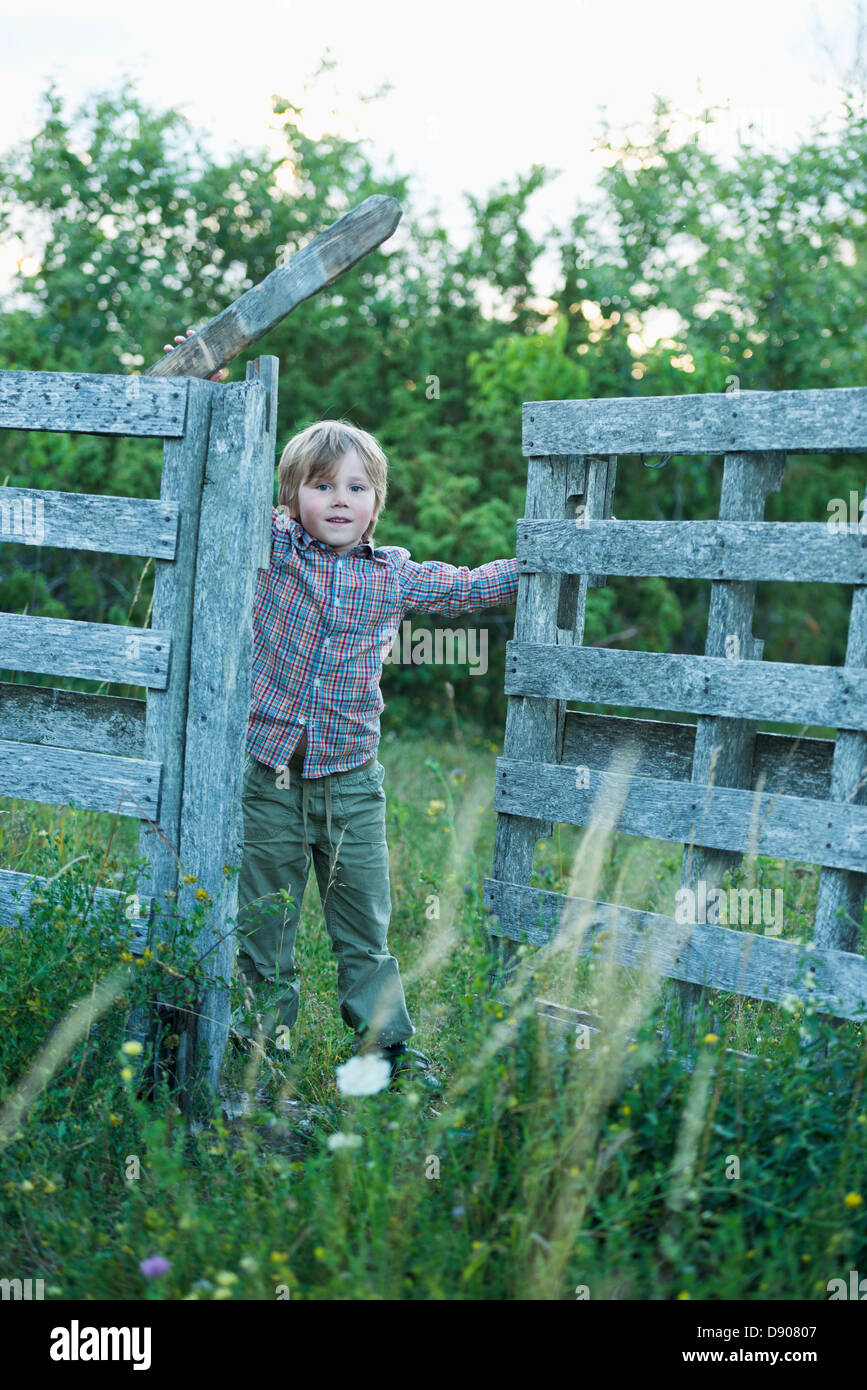 Boy standing near fence Stock Photo - Alamy