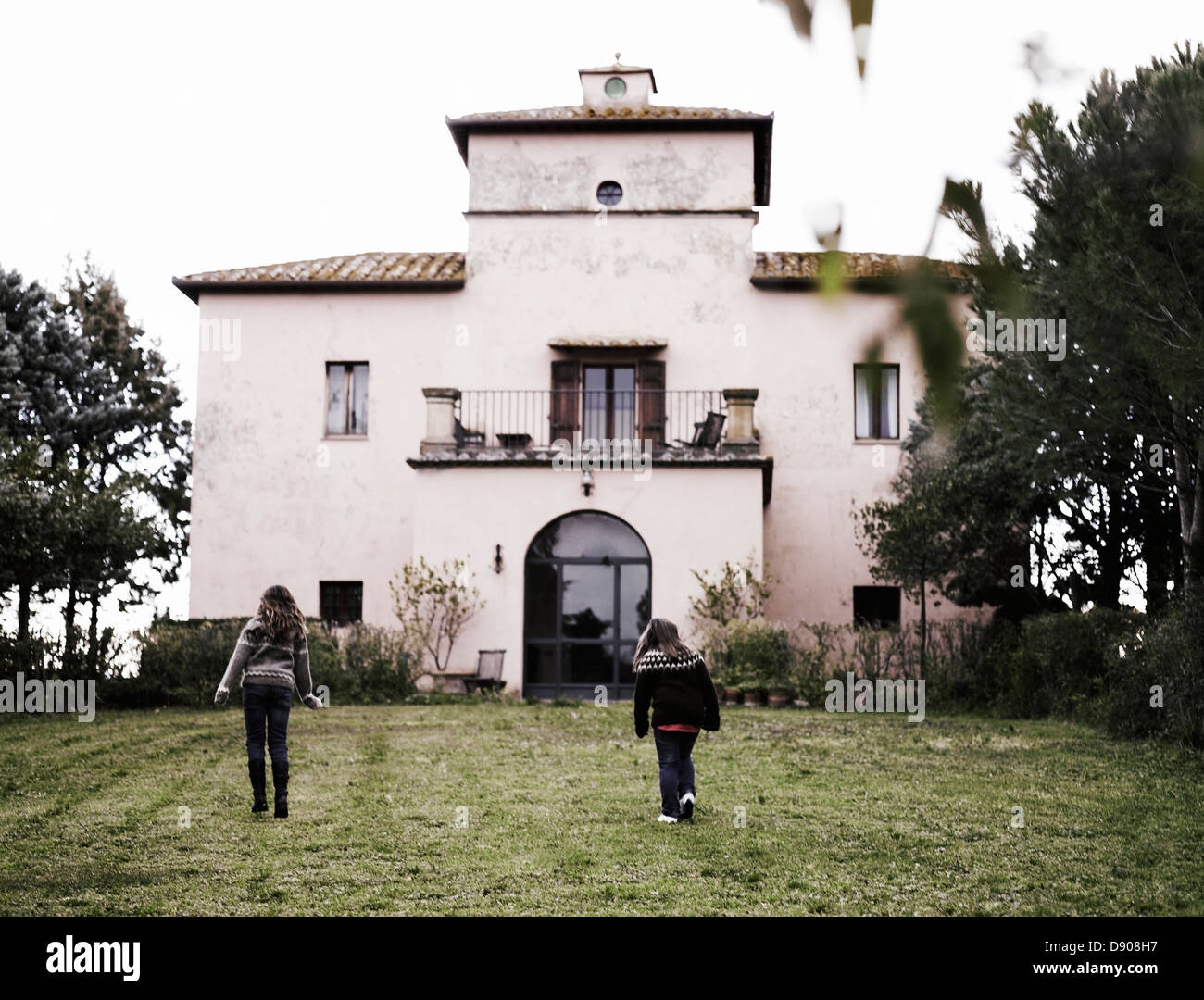 Two girls on lawn outside house Stock Photo - Alamy