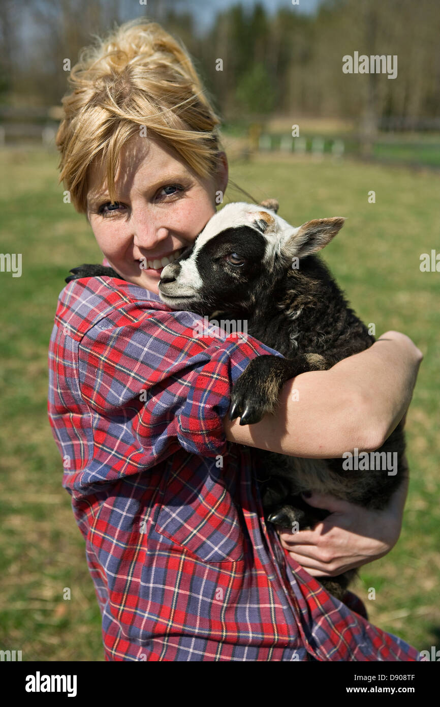 Woman hugging lamb in farm Stock Photo - Alamy