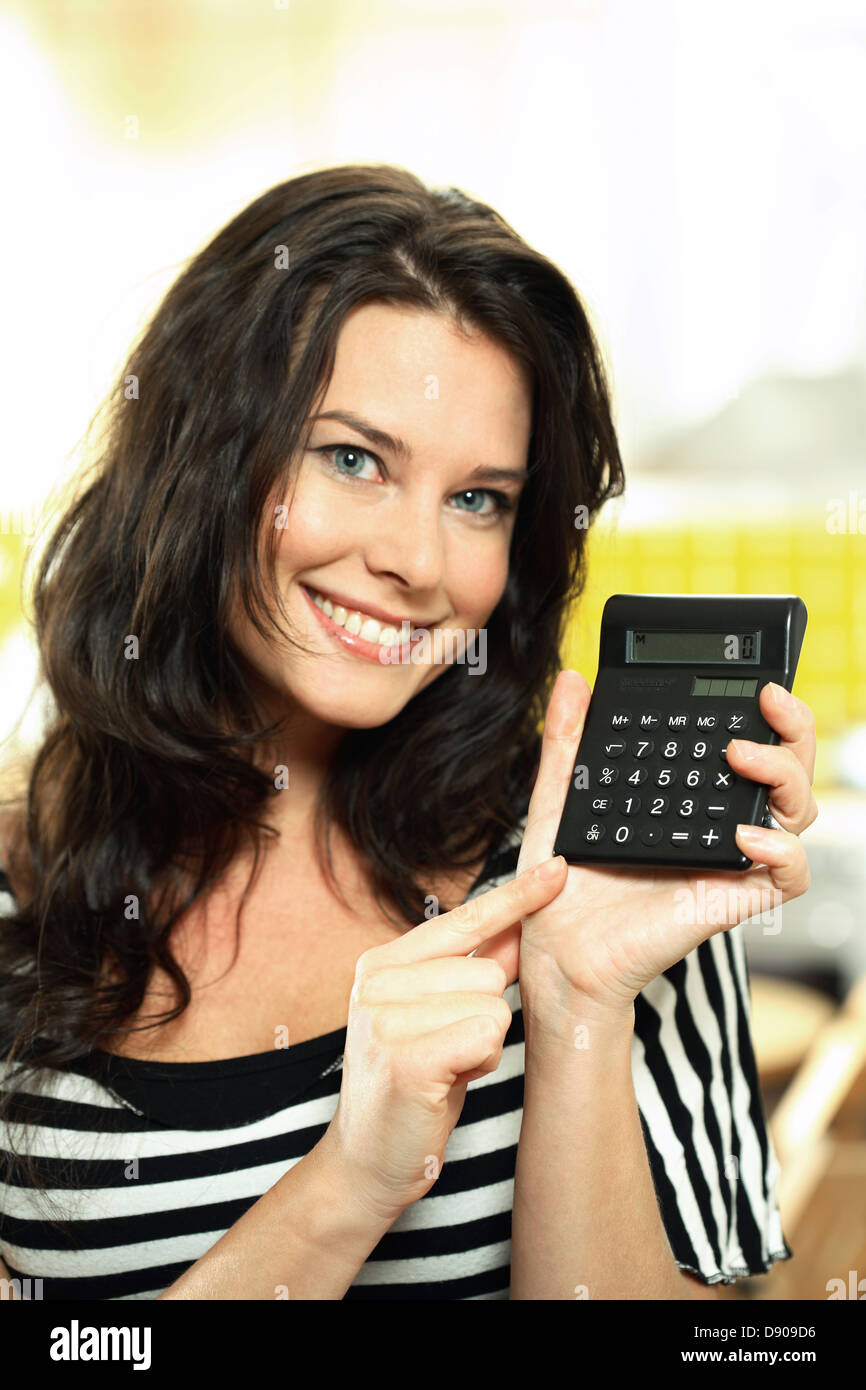 A smiling woman with a calculator Stock Photo - Alamy