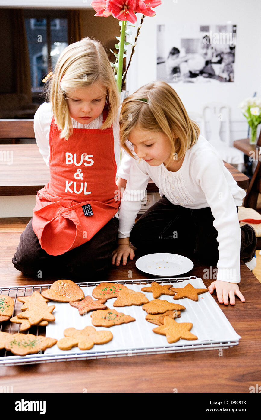 Two girls baking gingerbread bisquits Stock Photo - Alamy