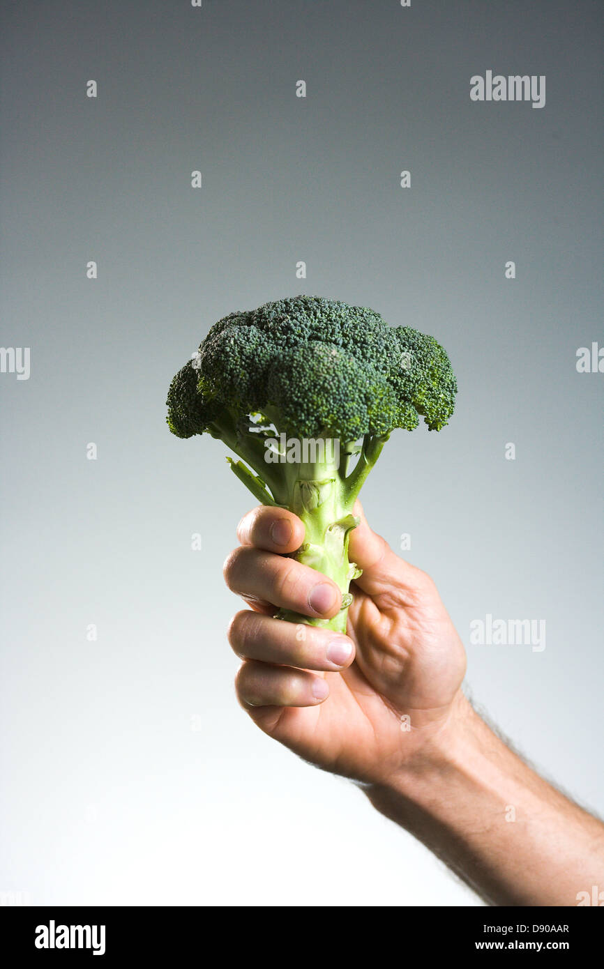 Man holding broccoli in his hand Stock Photo - Alamy