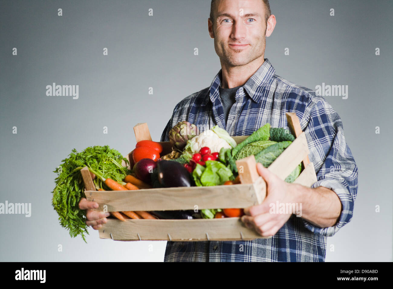 Man holding a box of vegetables Stock Photo - Alamy