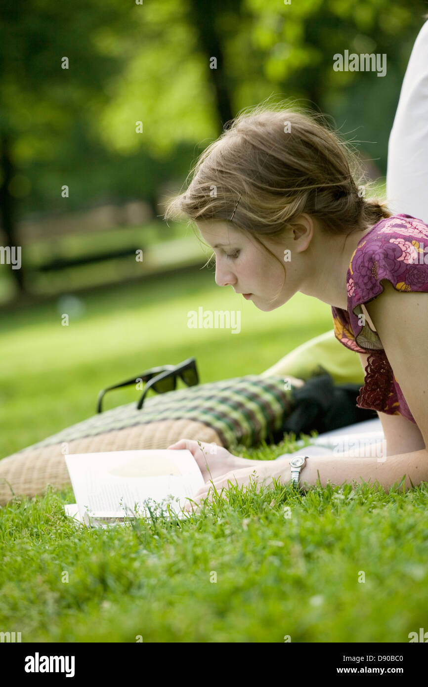 Young scandinavian woman reading a book outdoors, Sweden Stock Photo ...