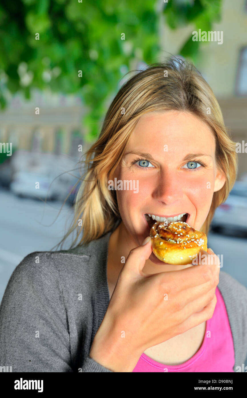 Woman eating a bun Stock Photo - Alamy