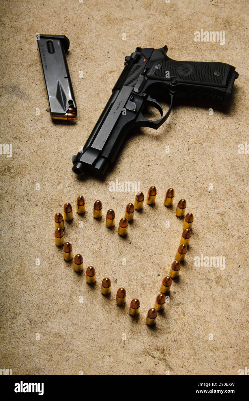 A gun and ammunition formed into a heart Stock Photo - Alamy
