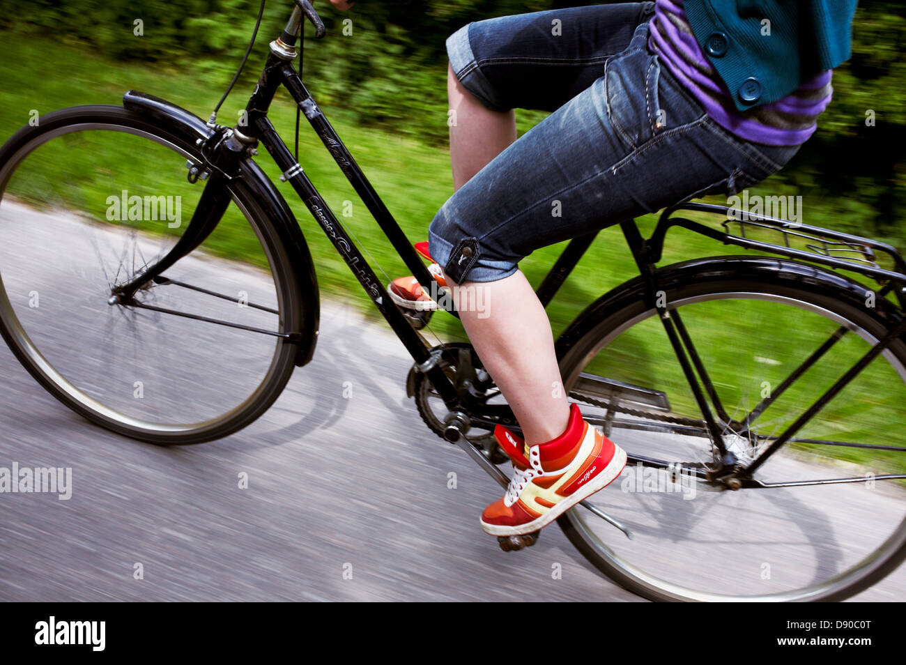Girl cycling on road Stock Photo - Alamy