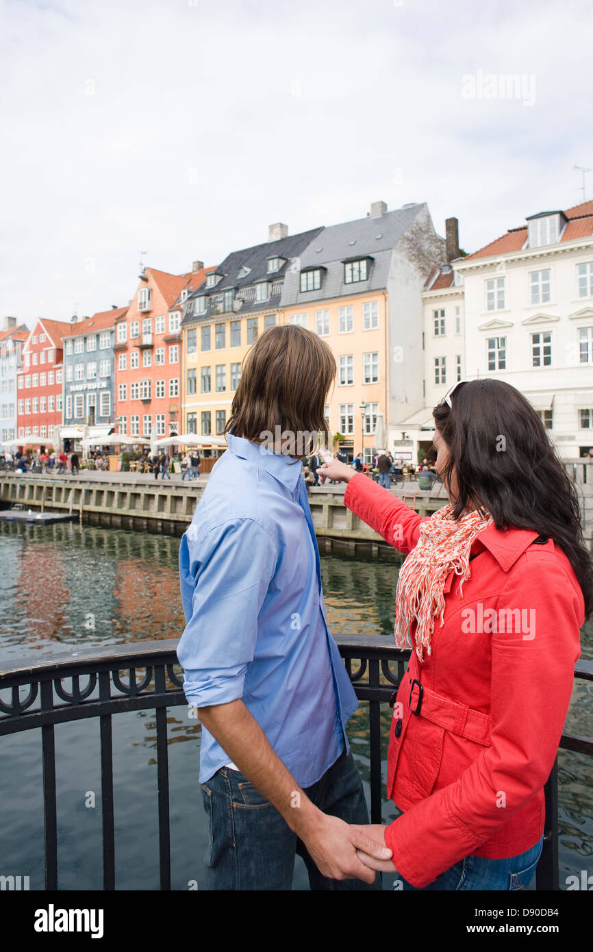 Young couple standing on bridge, pointing Stock Photo - Alamy