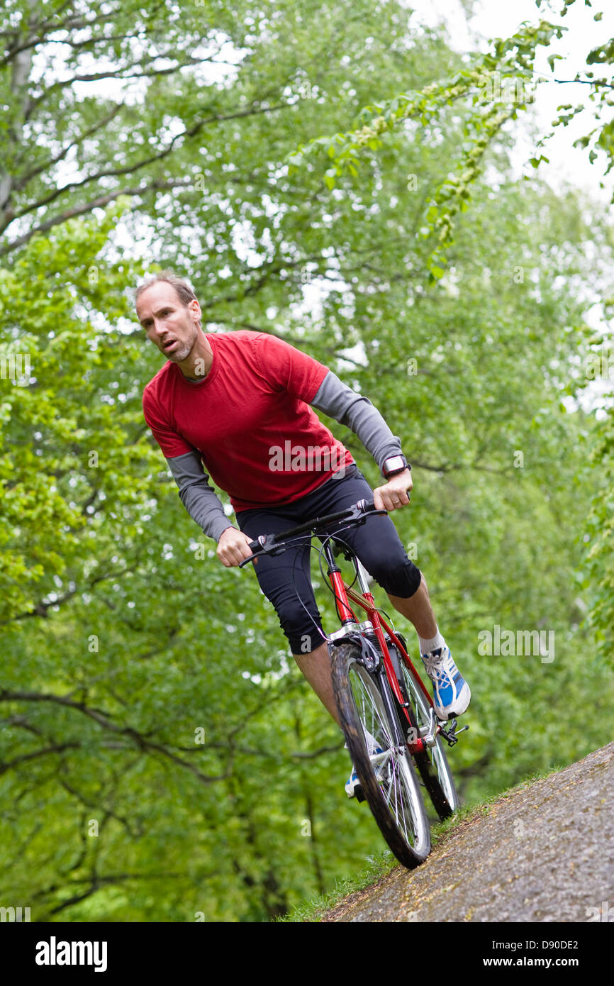 Man riding mountain bike in park Stock Photo - Alamy