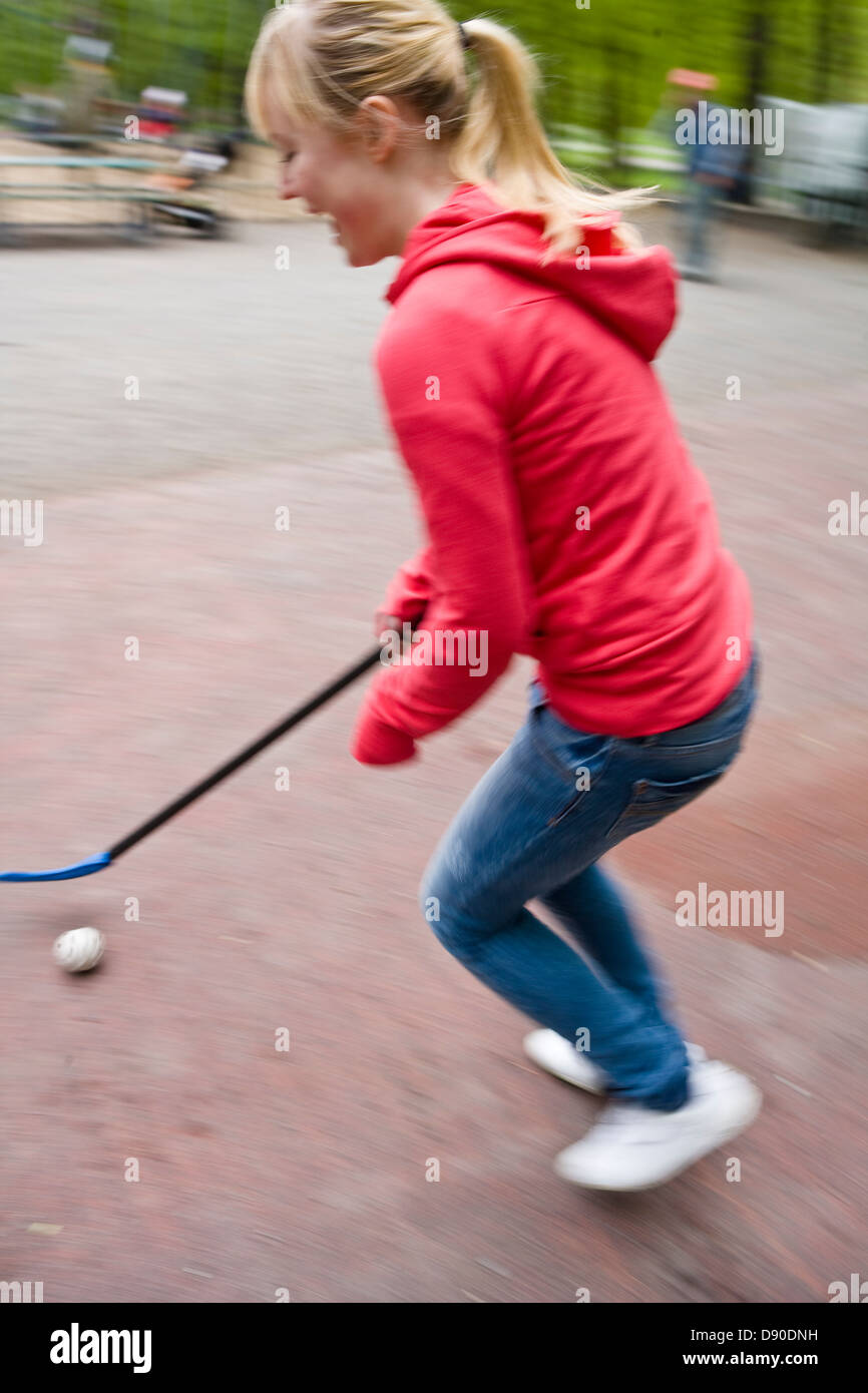 Teenage girl playing bandy in park Stock Photo - Alamy