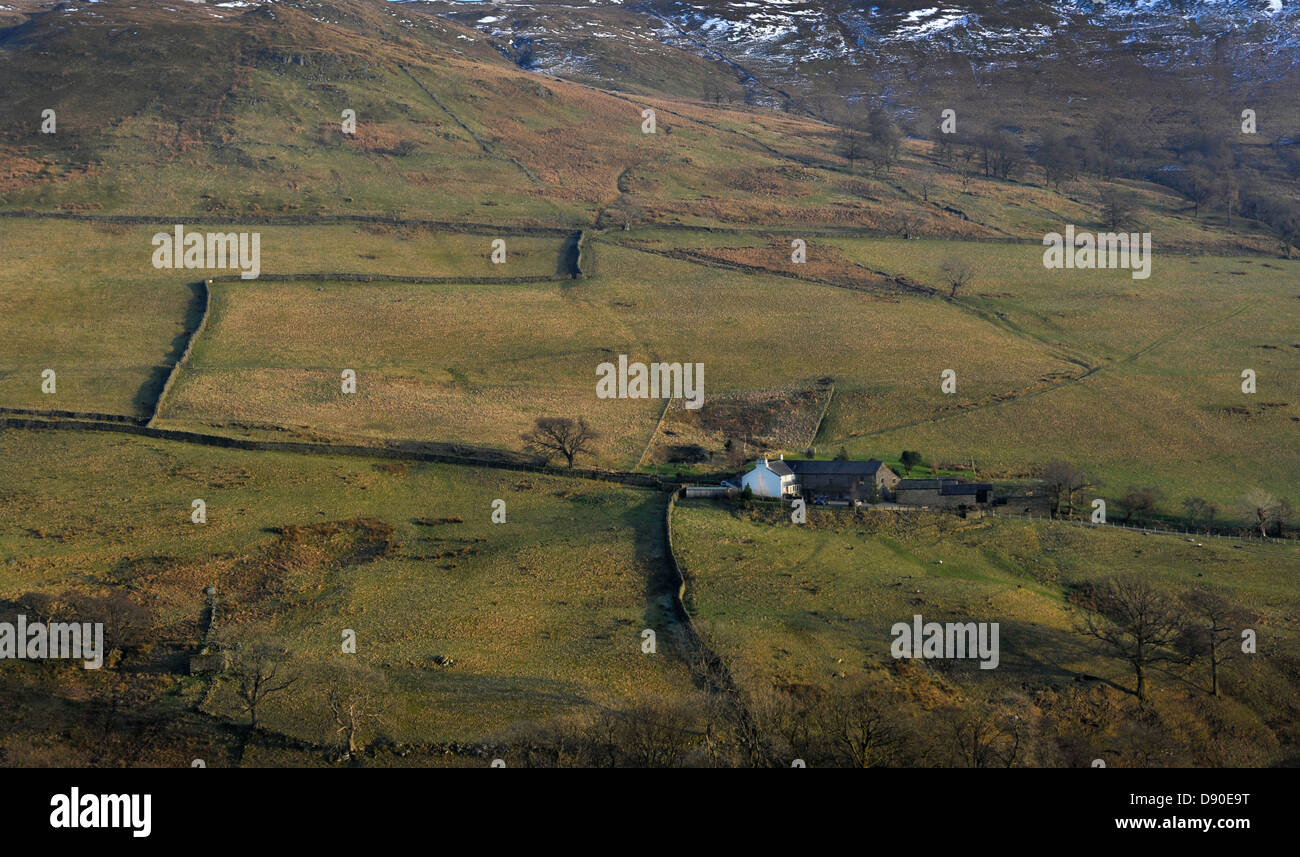 Seen from a distance a small hillside farms buildings walls fields and ...