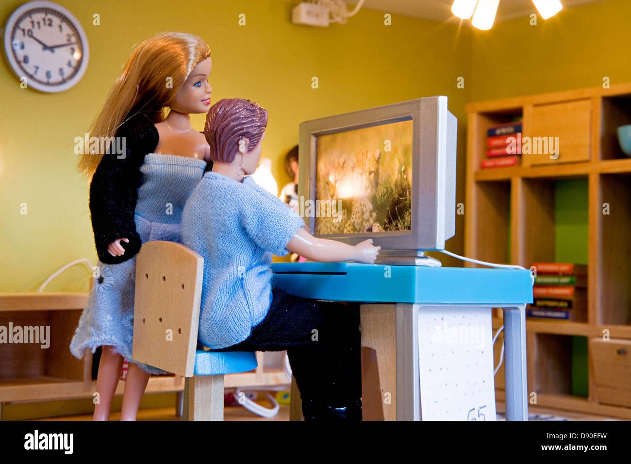 A couple of barbie dolls infront of a computer in a dollhouse Stock ...
