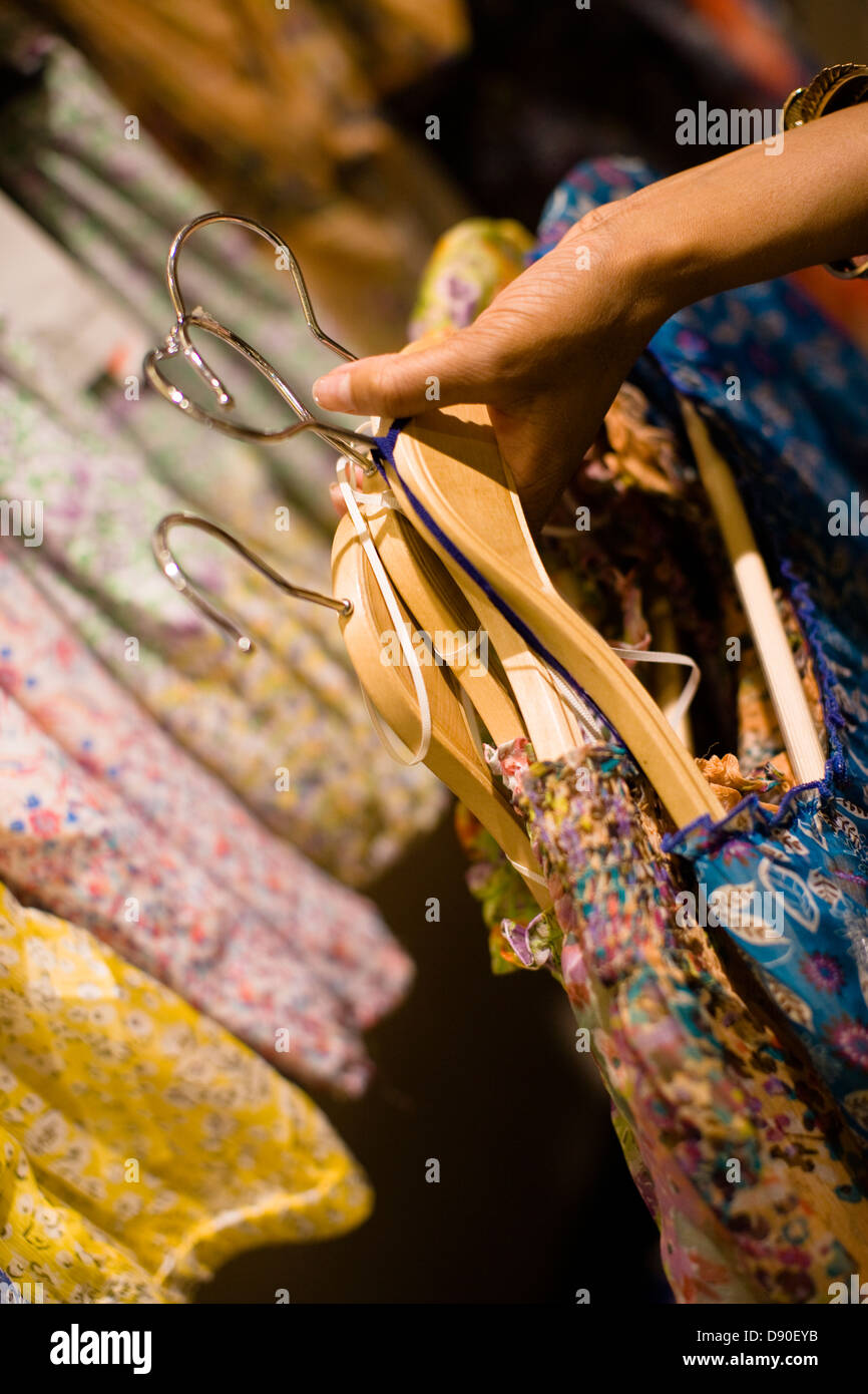 Woman holding clothes on hangers Stock Photo - Alamy