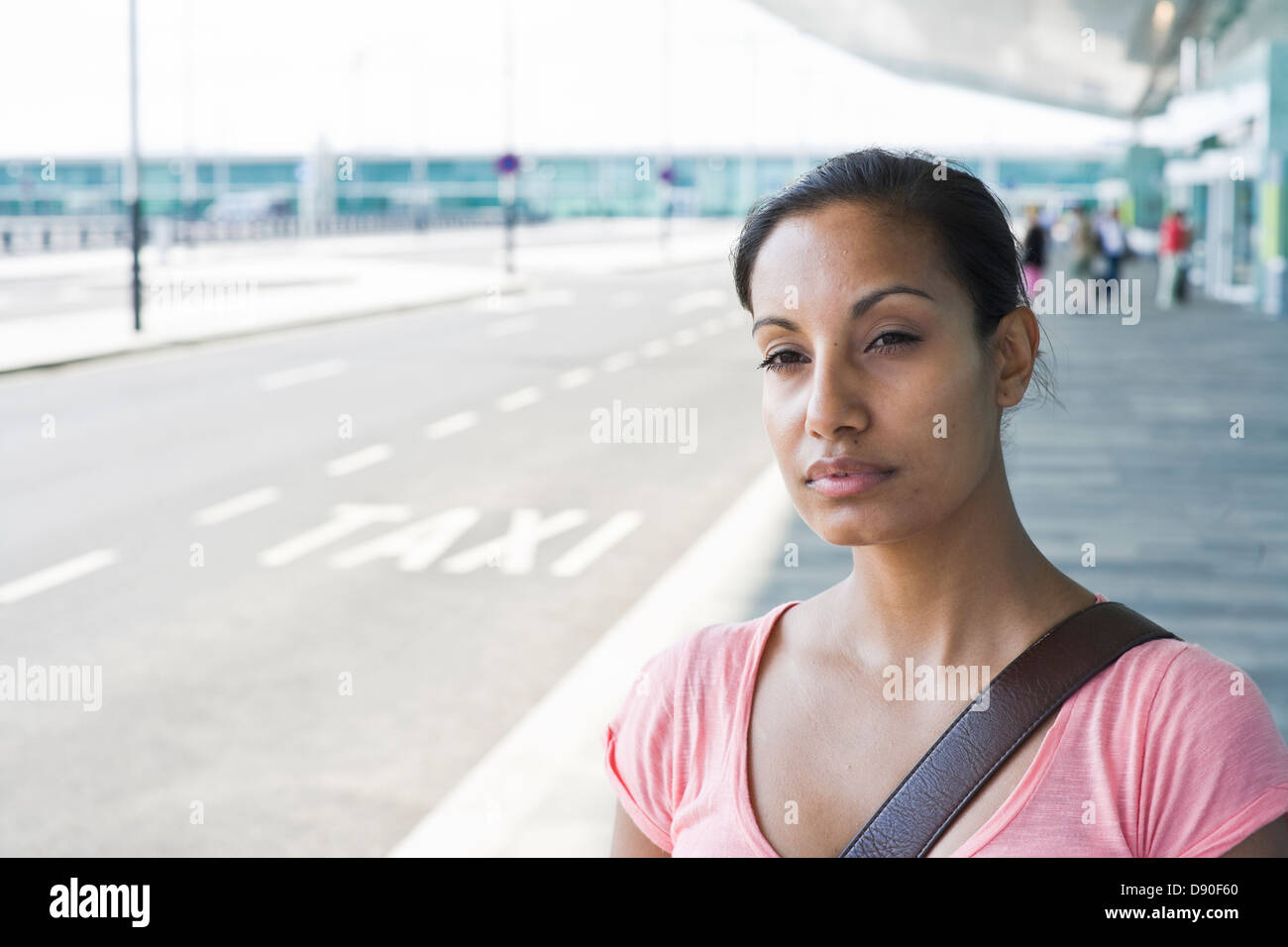 Woman waiting on taxi outside airport Stock Photo - Alamy