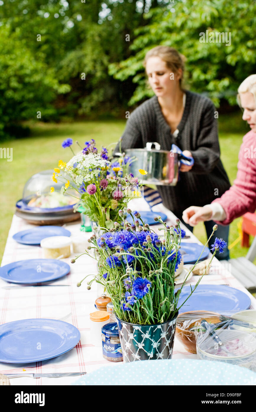 Women preparing dining table Stock Photo - Alamy