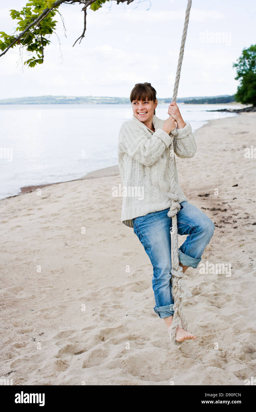 Woman swinging on rope Stock Photo - Alamy