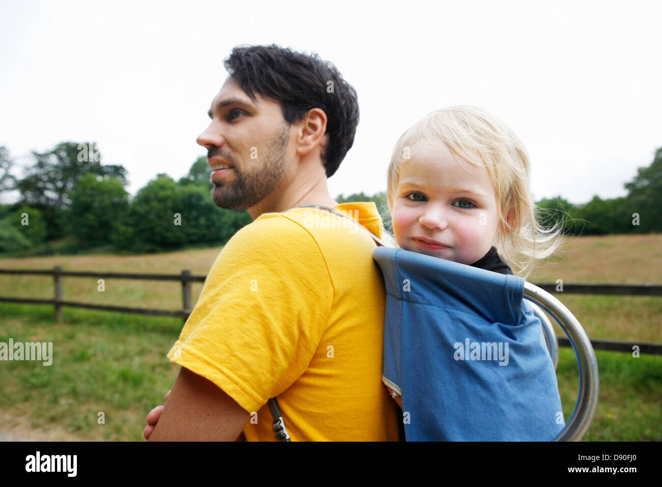 Father carrying daughter in baby carrier Stock Photo - Alamy