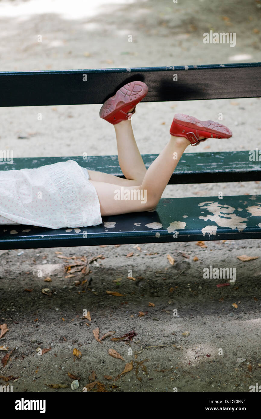 Girl lying on a bench, France Stock Photo - Alamy