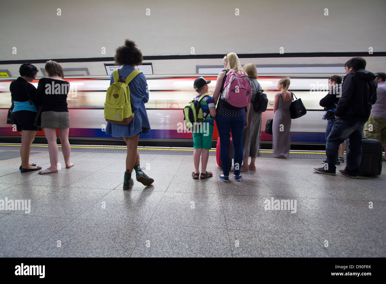 Tube passengers waiting for train at London Station with train arriving ...