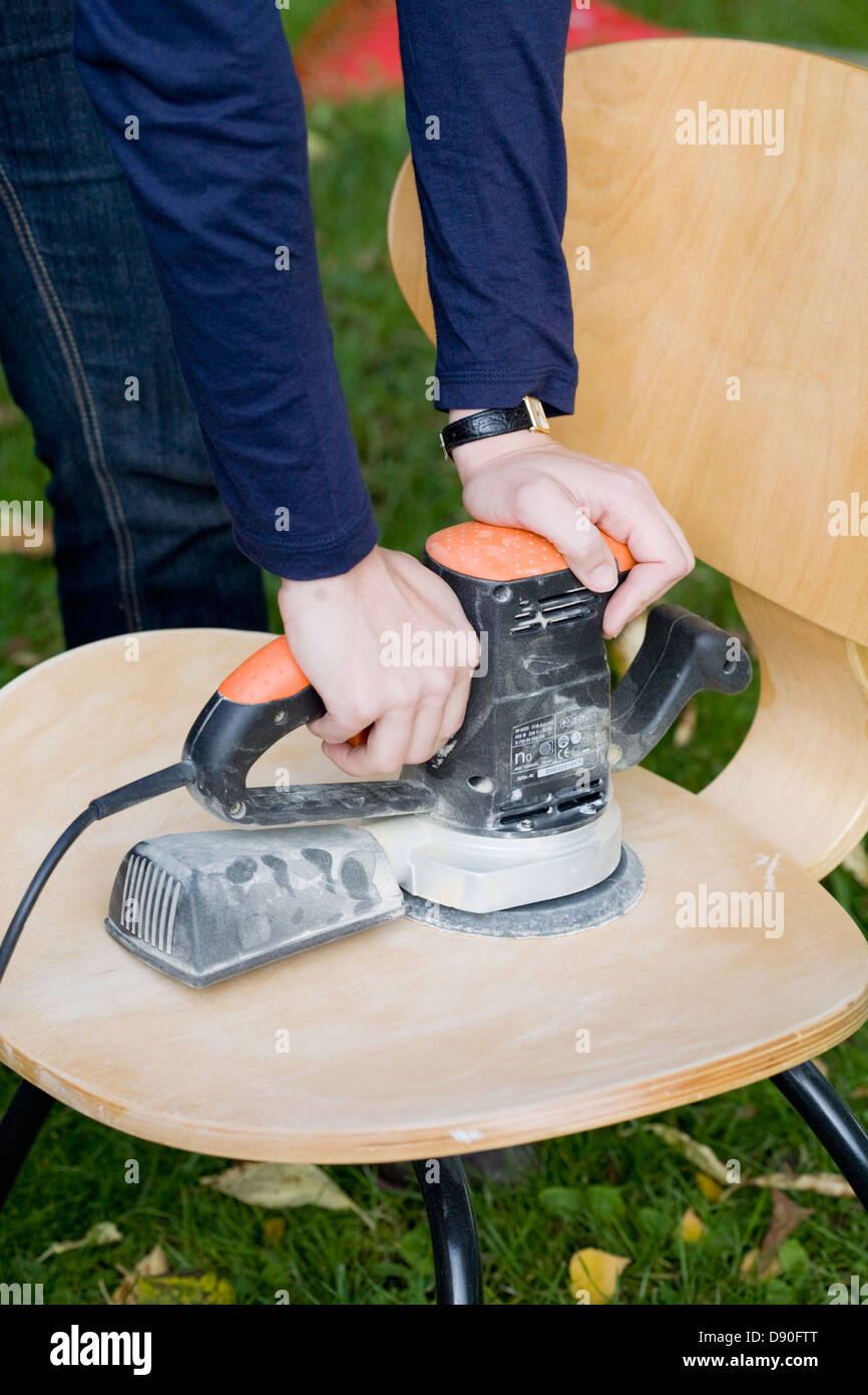 Woman smoothing chair surface Stock Photo - Alamy
