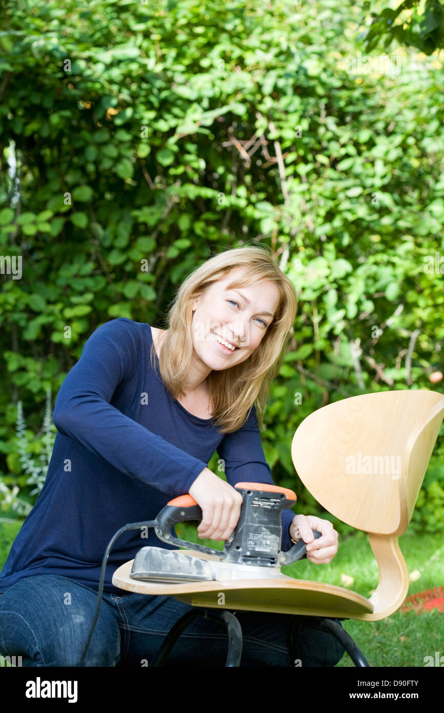 Woman smoothing chair surface Stock Photo - Alamy