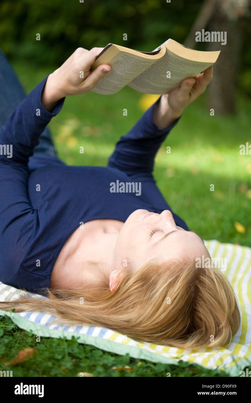 Woman reading in lawn Stock Photo - Alamy