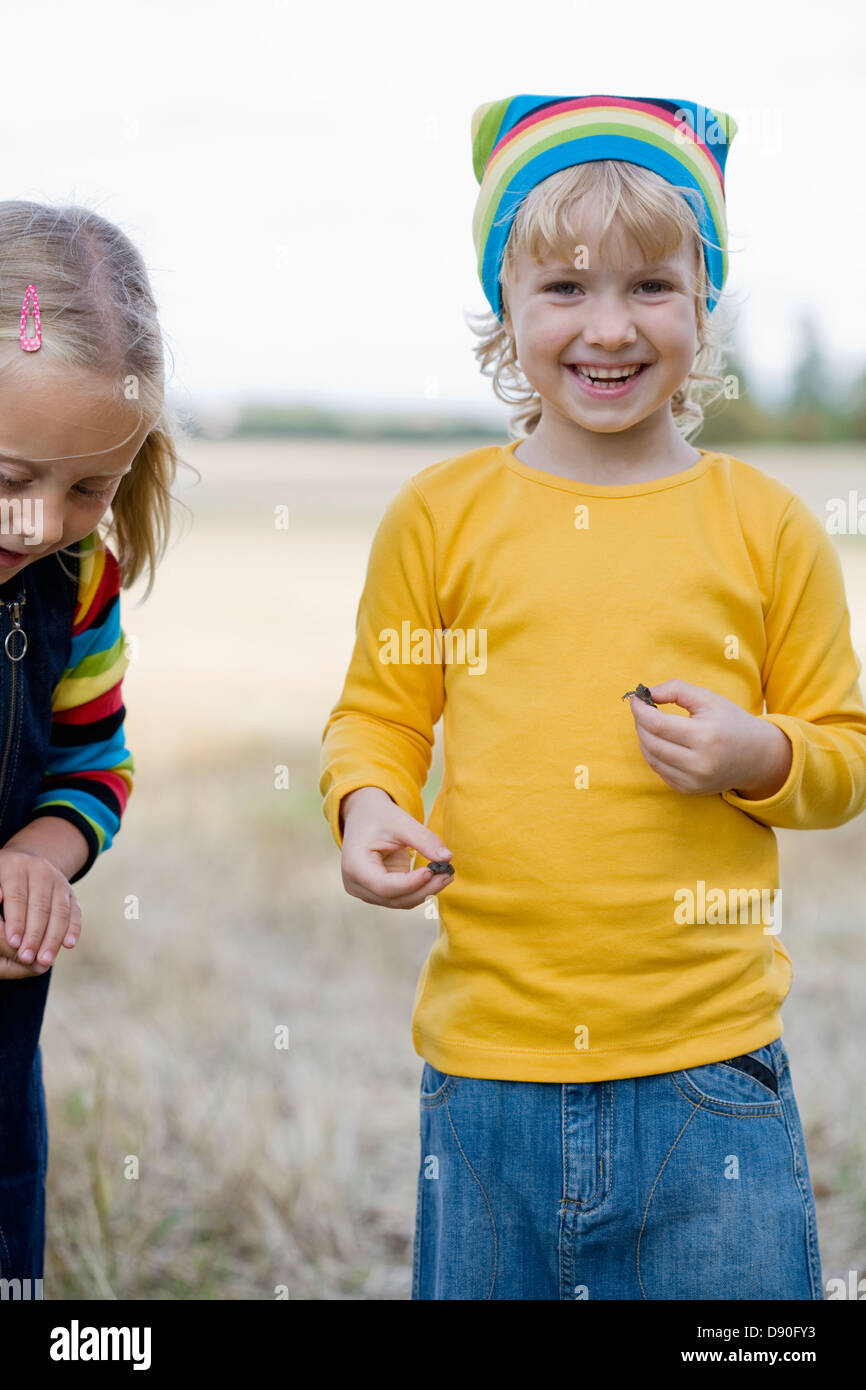Two girls catching frog Stock Photo - Alamy