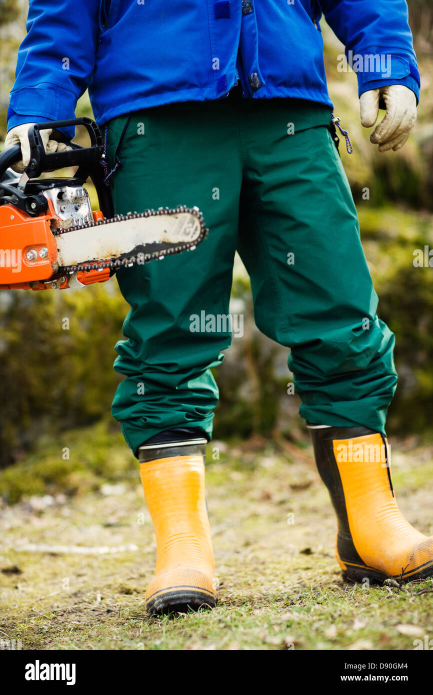 A man holding a chainsaw, Sweden Stock Photo - Alamy