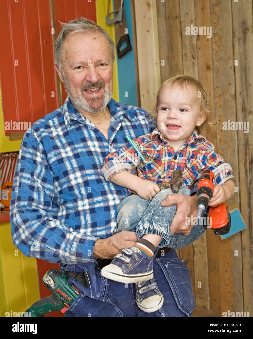 A senior man doing carpentry with his grandchild, Sweden Stock Photo ...