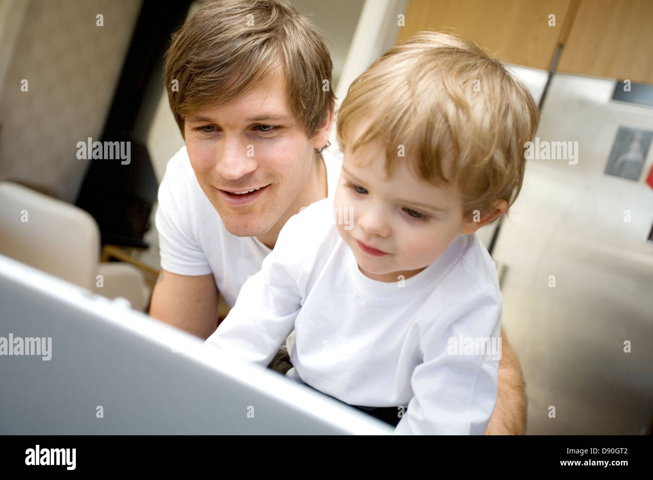 A father and a small child infront of a computer, at home, Sweden Stock ...