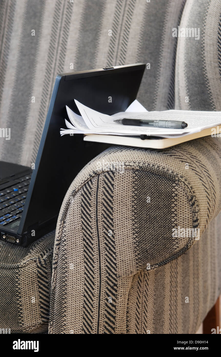 A laptop, arm chair and papers Stock Photo - Alamy
