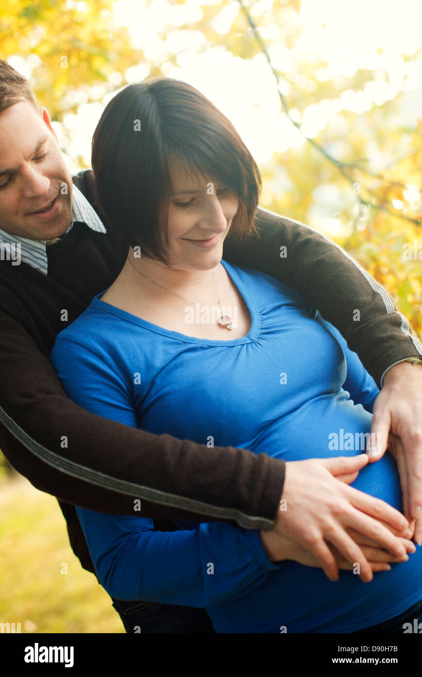 Couple touching stomach and hugging Stock Photo - Alamy