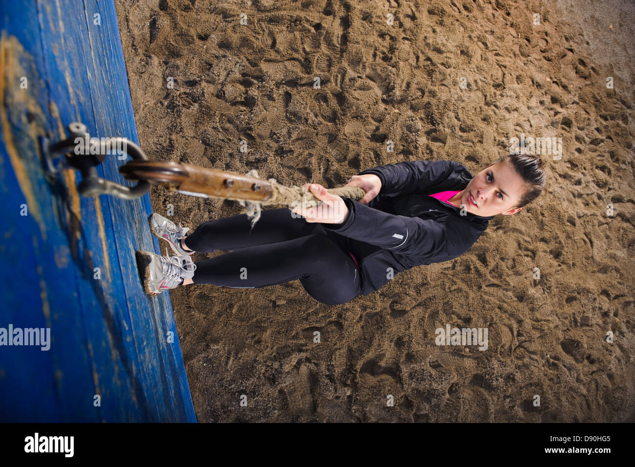 Woman climbing wall using rope in obstacle course Stock Photo - Alamy