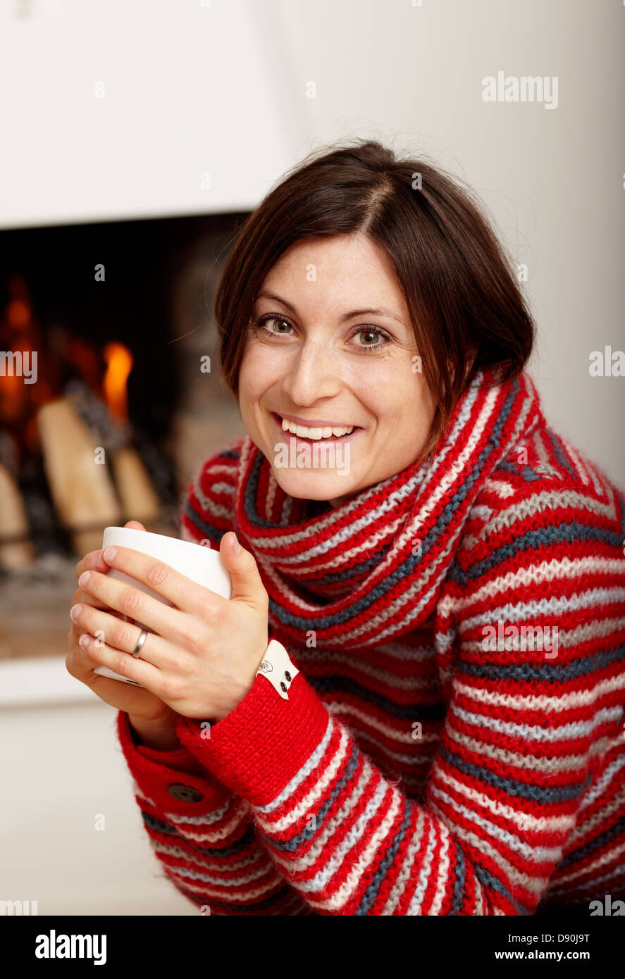 Woman drinking tea near fireplace Stock Photo - Alamy
