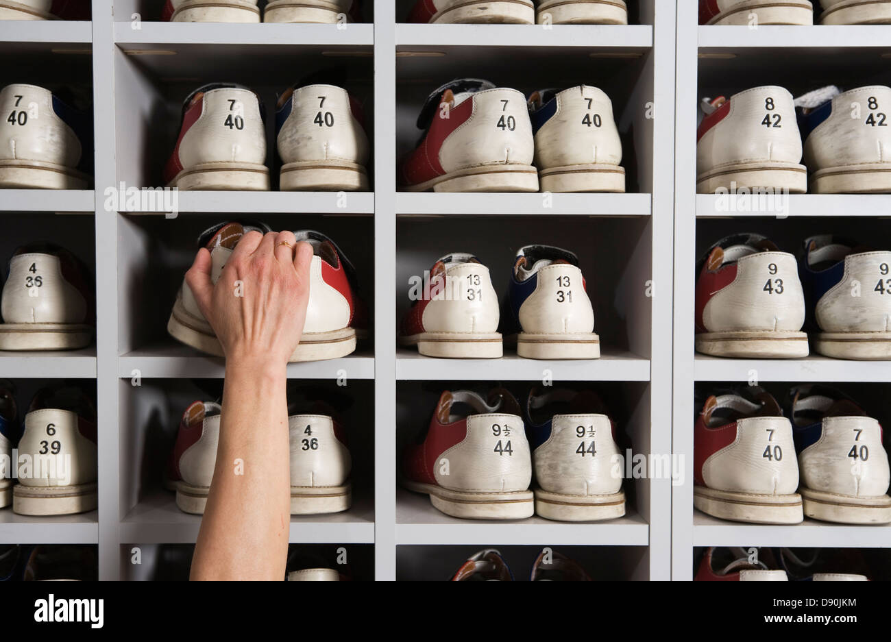 Hand picking shoes on shelves in a bowling alley Stock Photo - Alamy
