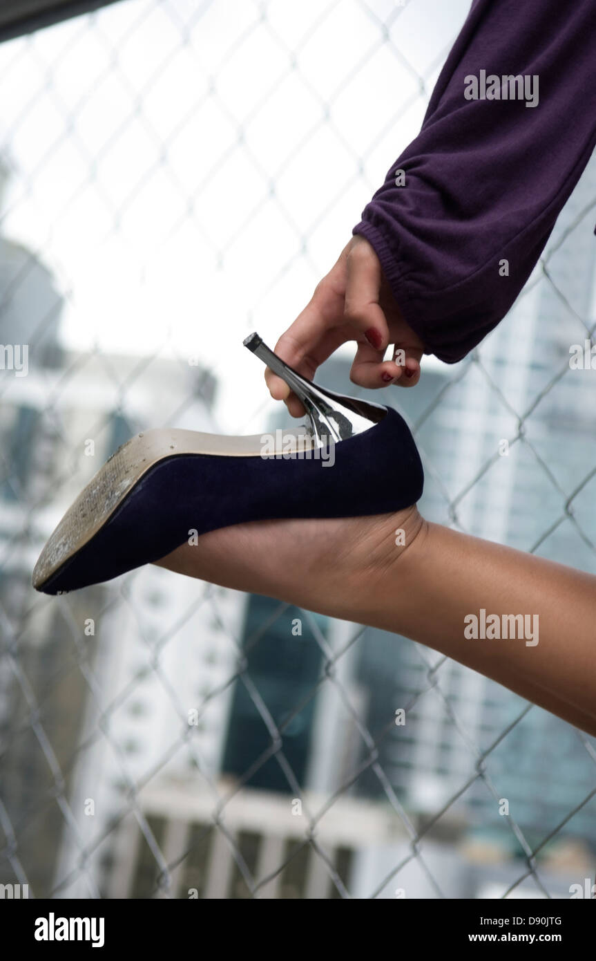 Hand holding high heel shoe Stock Photo - Alamy