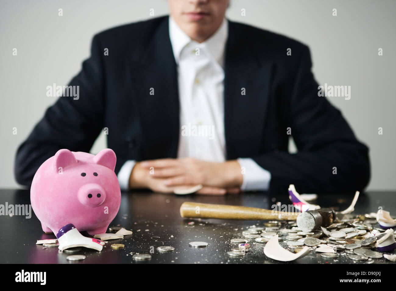 A man with an unbroken and a broken piggy bank Stock Photo - Alamy