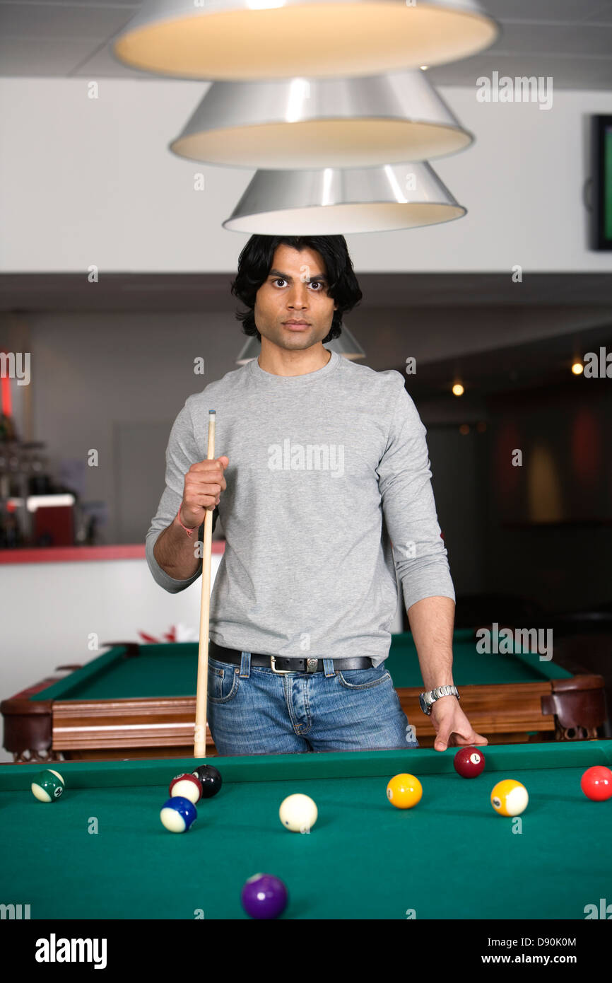 Man standing by a pool table Stock Photo - Alamy