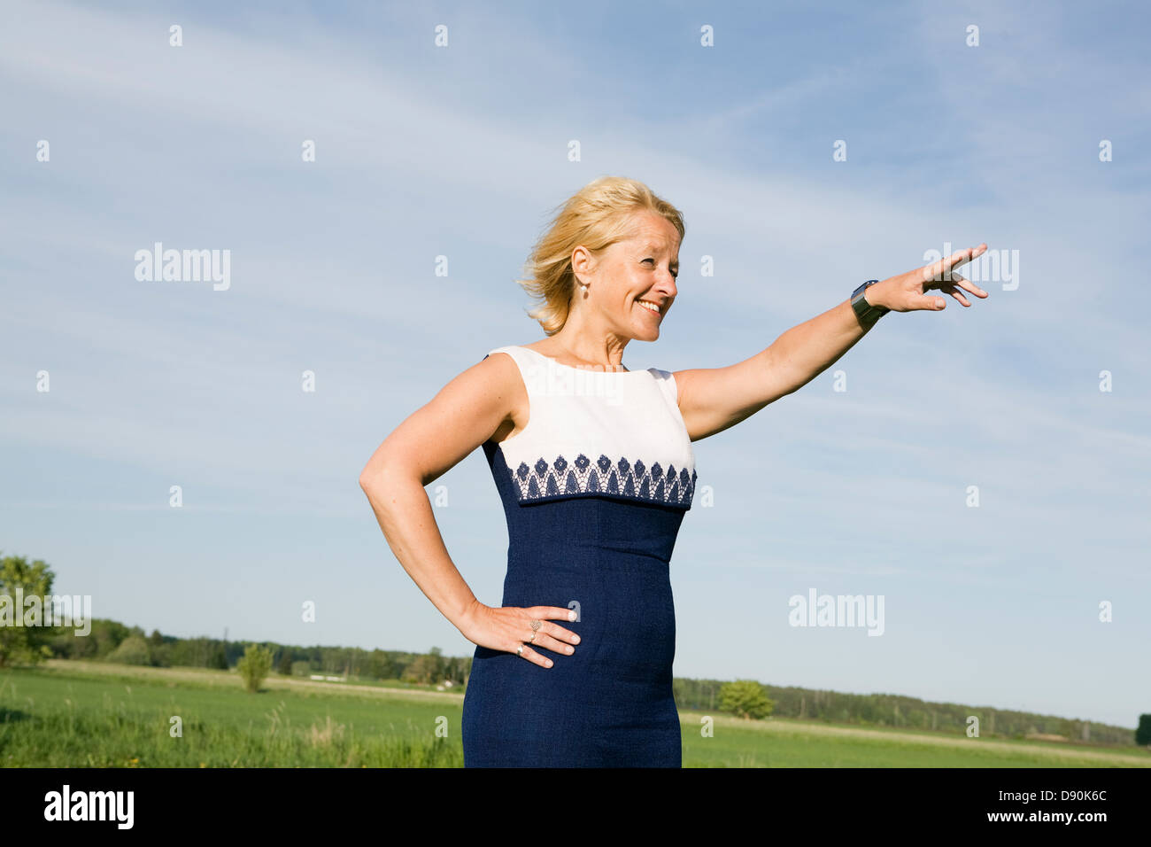 Smiling mature woman pointing outdoors Stock Photo - Alamy