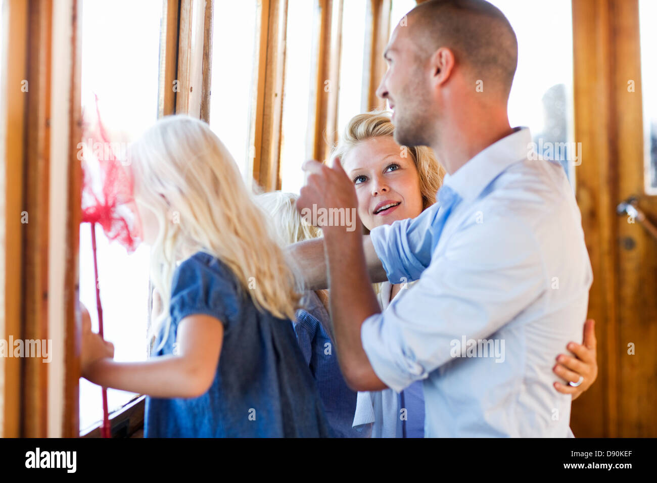 Family standing beside window, smiling Stock Photo - Alamy