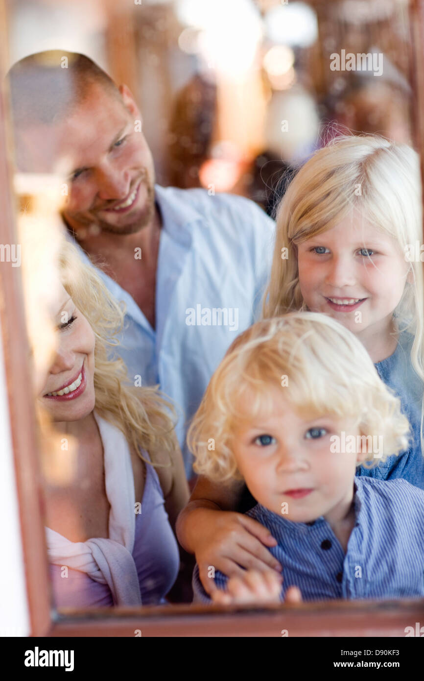 Family standing beside window, smiling Stock Photo - Alamy