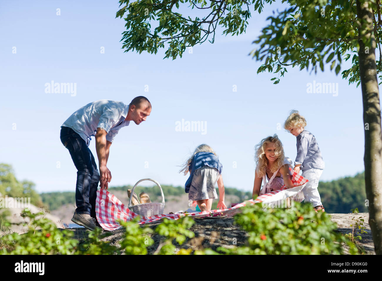 Family laying down blanket for picnic Stock Photo - Alamy