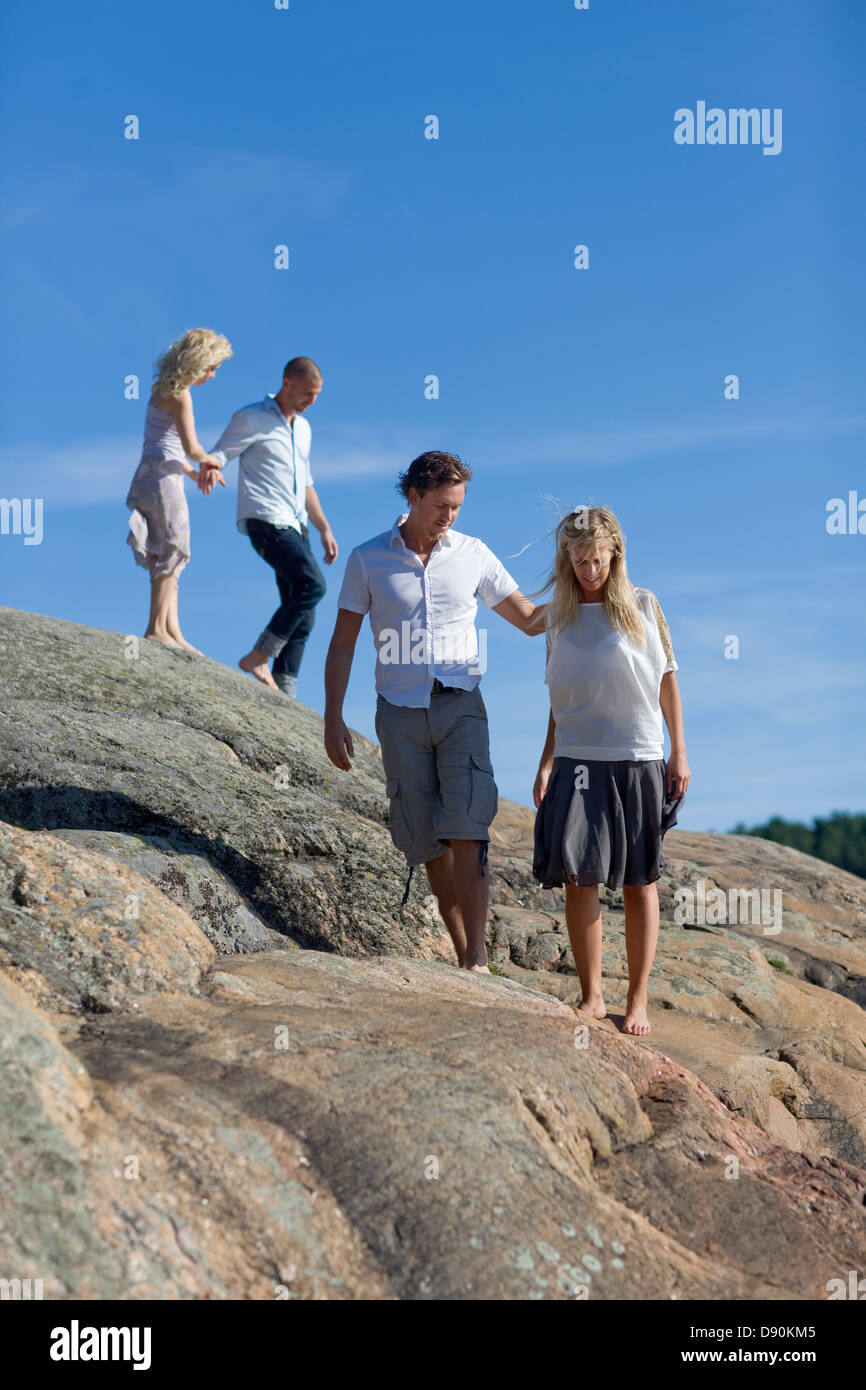 Two couples walking together on rock Stock Photo - Alamy