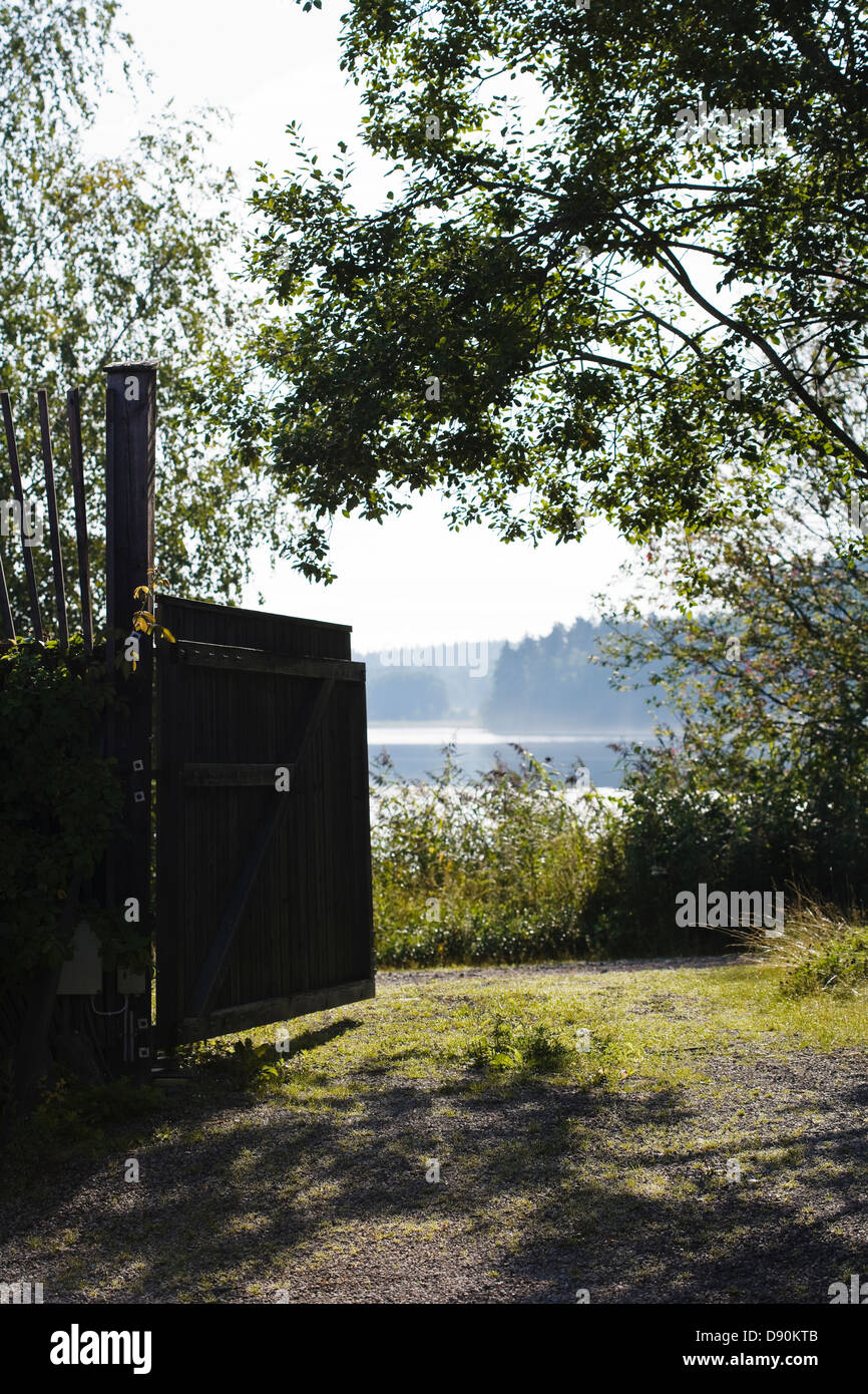View of gate with trees beside lake Stock Photo - Alamy