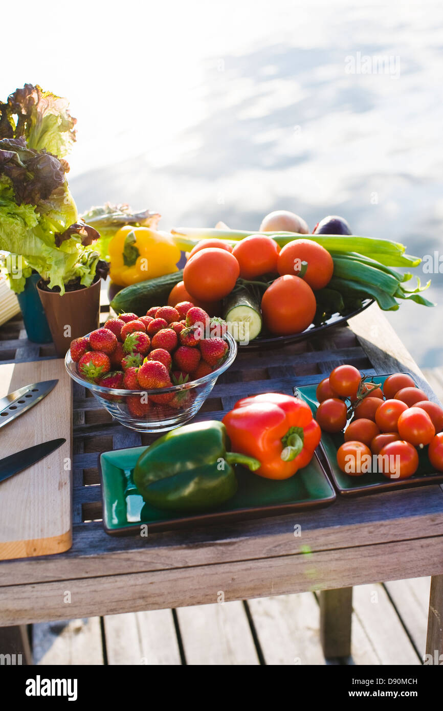 Vegetables and fruits on jetty by lake Stock Photo - Alamy