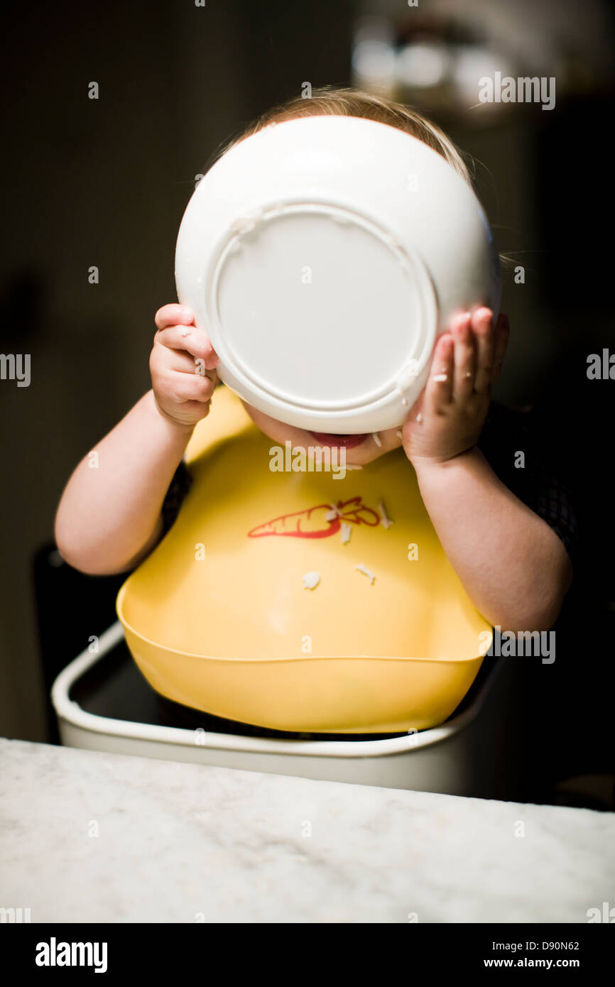 Boy wearing bib eating from bowl Stock Photo - Alamy
