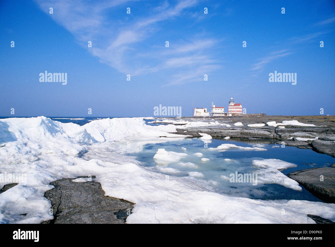 Snow-covered sea with houses in background Stock Photo - Alamy