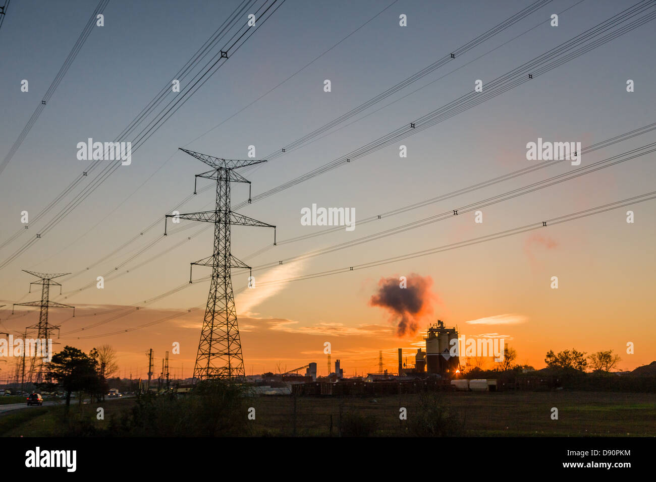 Sunset scene with Hydro Towers and Power lines with industrial site in ...