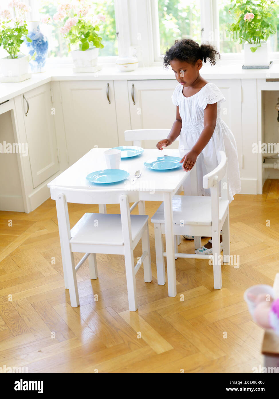 Girl setting small table Stock Photo - Alamy